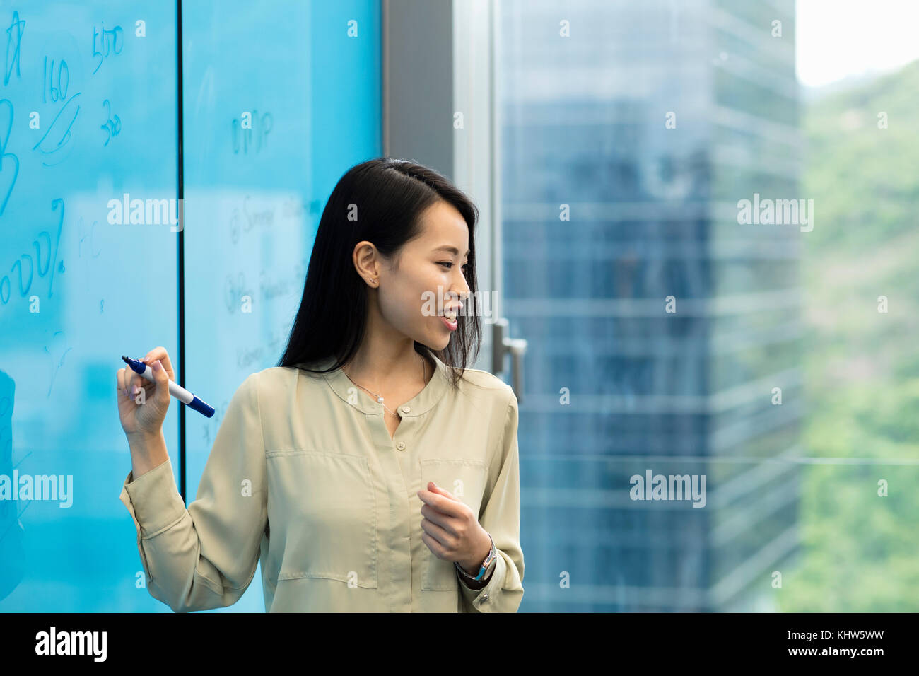 Woman writing on board Stock Photo - Alamy