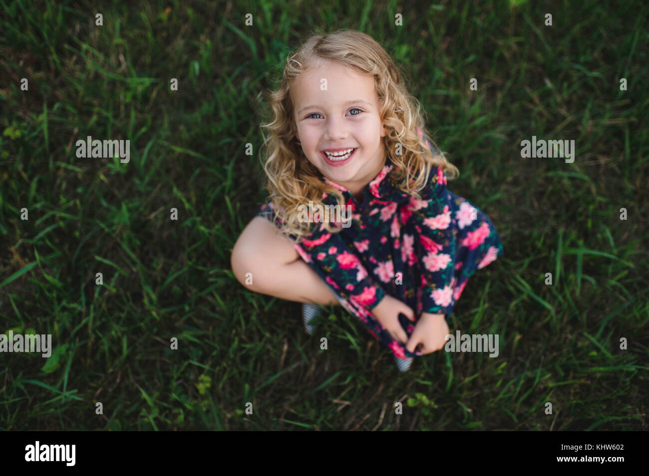 Overhead portrait of blond haired girl sitting on grass Stock Photo - Alamy