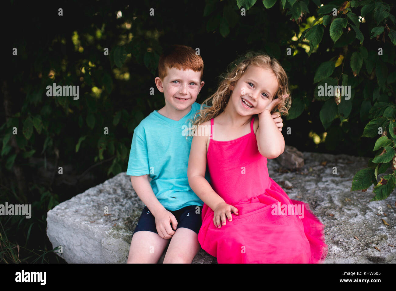 Boy girl sitting on rock hi-res stock photography and images - Alamy