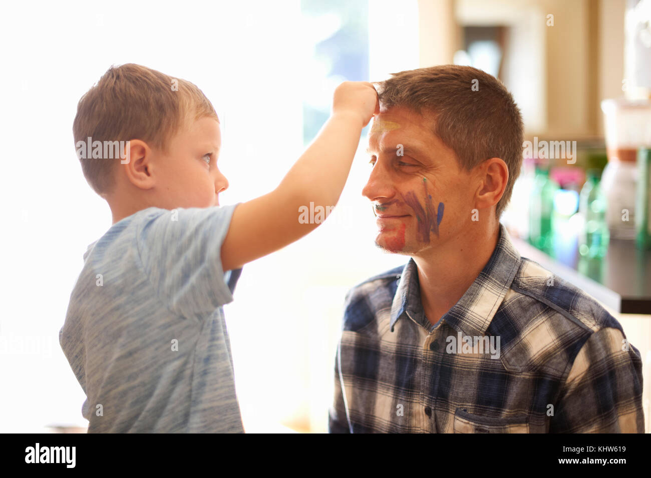 Young boy drawing on father's face using face paint Stock Photo - Alamy