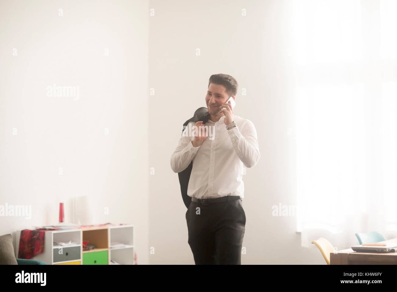 Young man working from home making smartphone call Stock Photo - Alamy