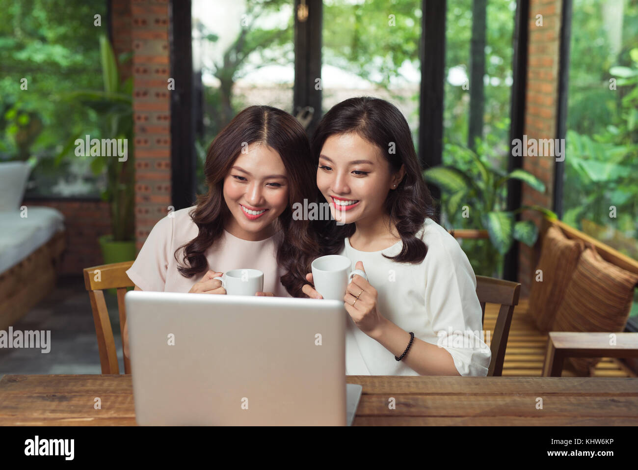 Young female friends surfing the internet together on a laptop Stock ...