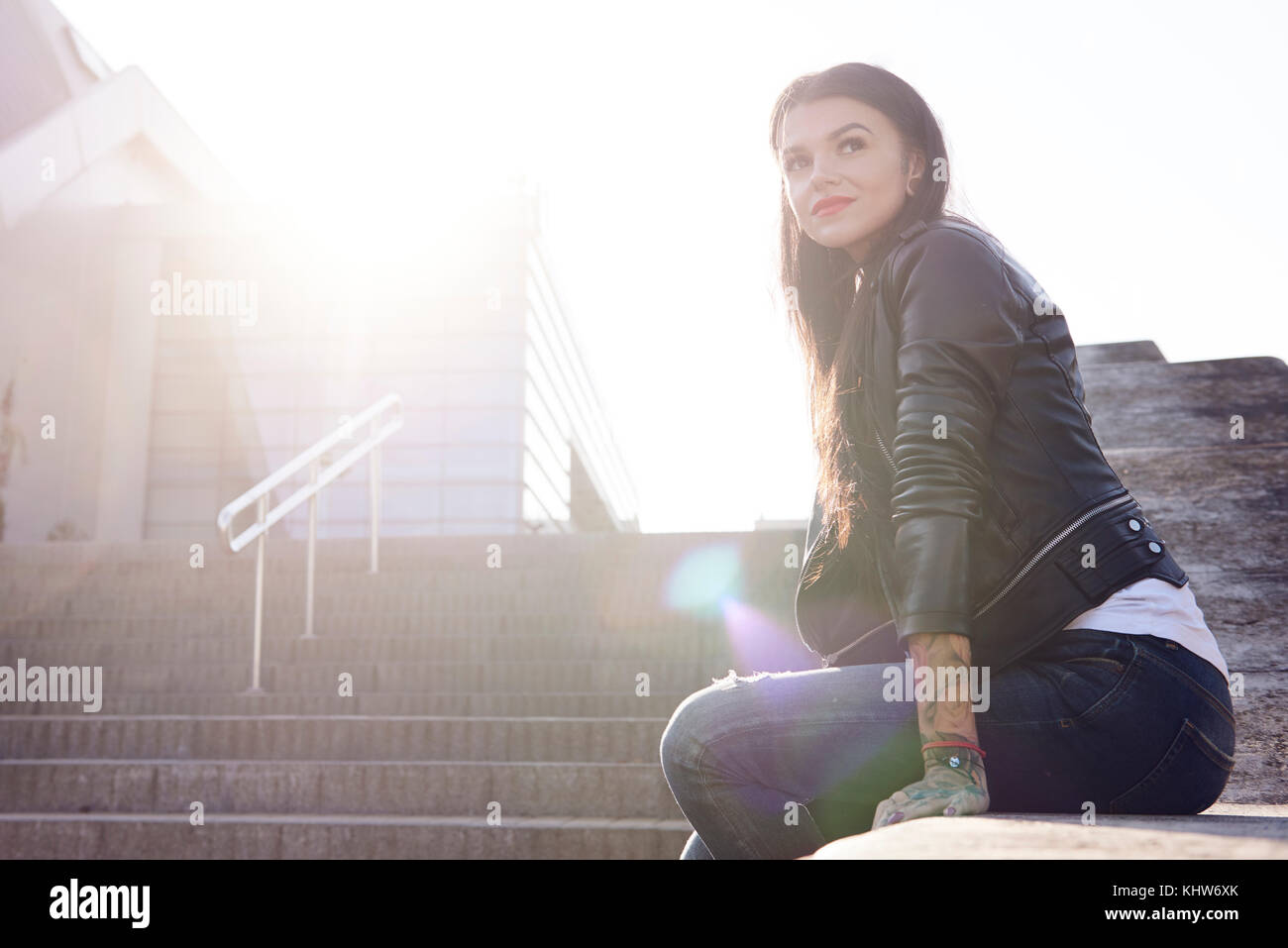 Young woman sitting wall hi-res stock photography and images - Alamy