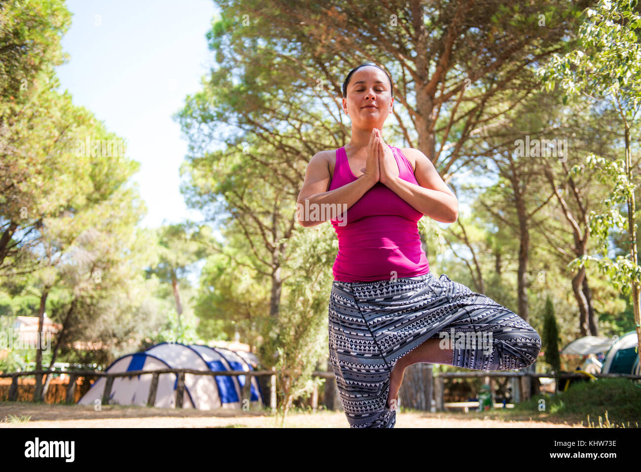 Mature woman practicing yoga tree pose on camping site Stock Photo - Alamy