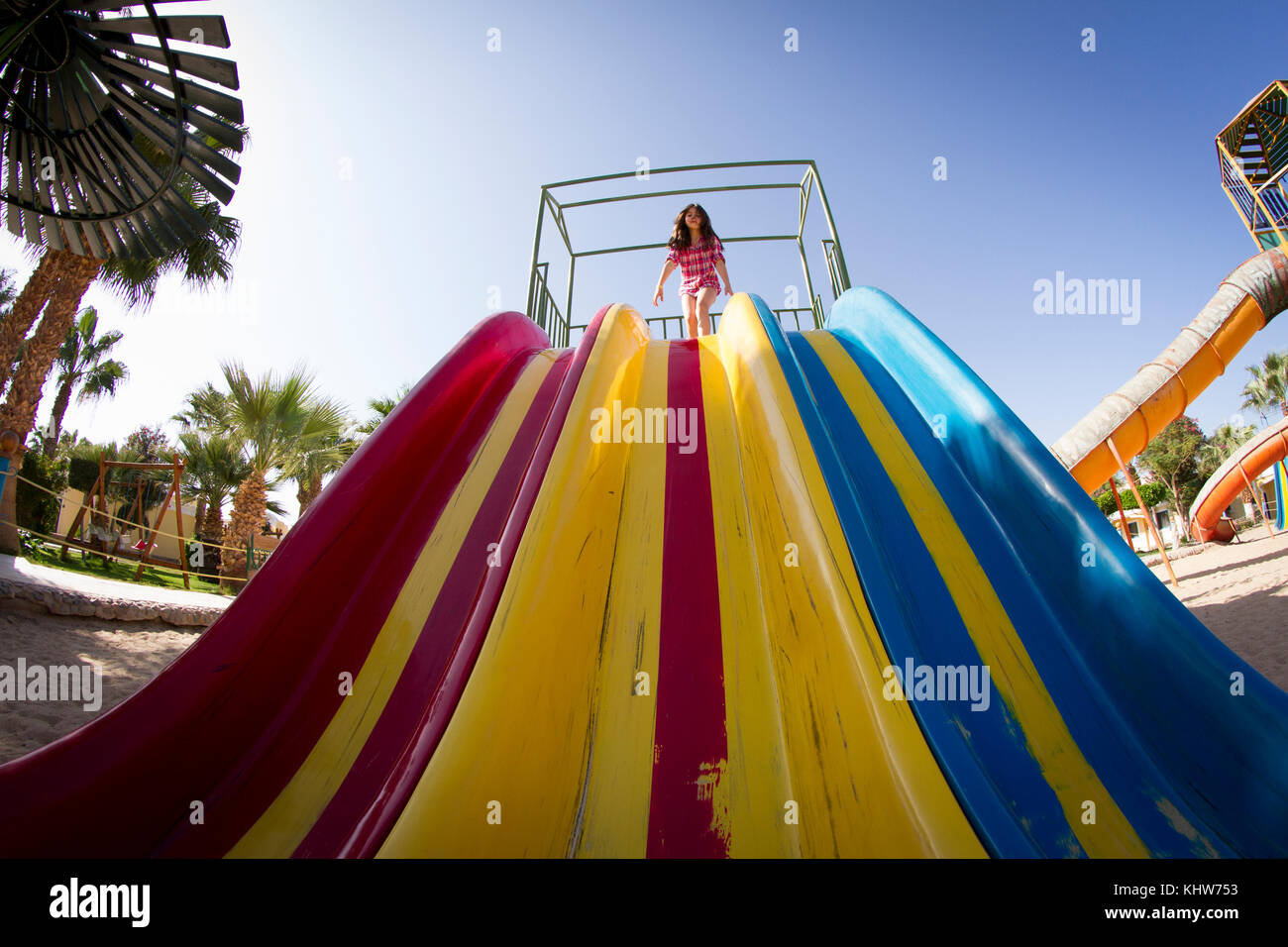 Low angle view of girl preparing to slide on play park slide Stock ...