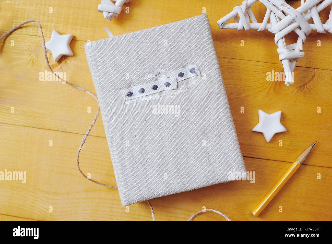 Notebook on a wooden background with a decor of white stars Flat lay ...