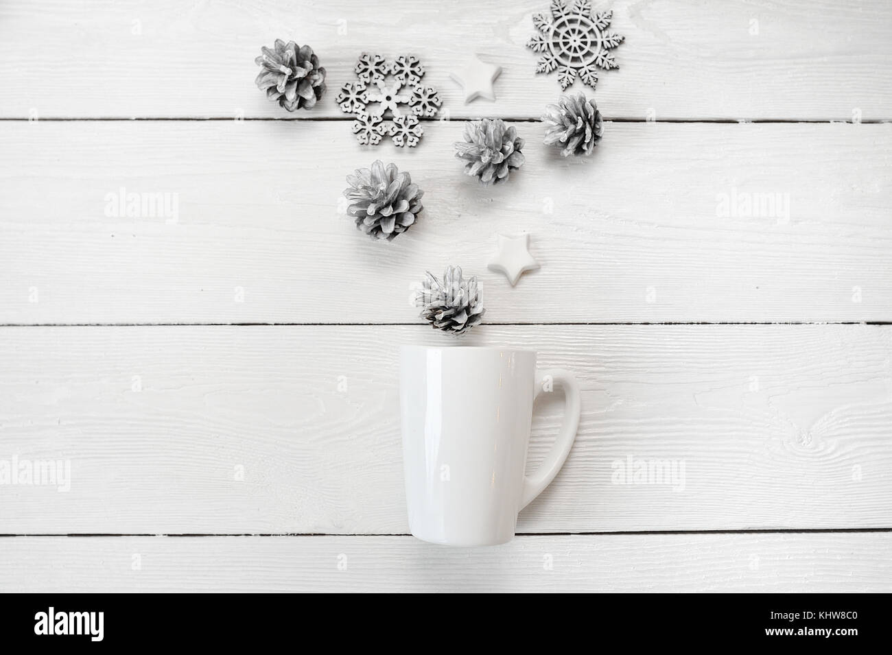 Mockup white mug with christmas cones and stars, on a white wooden ...