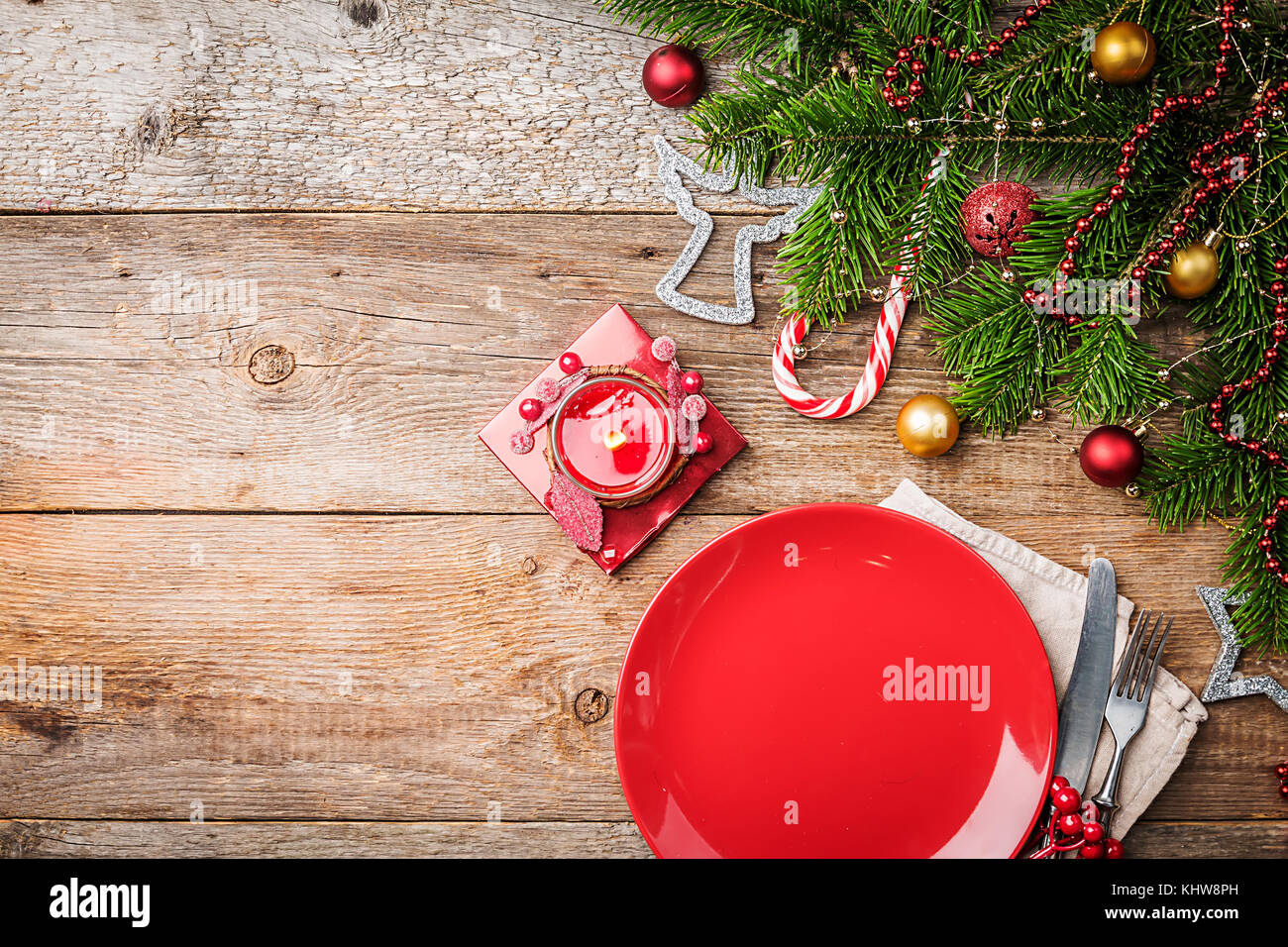 Christmas table place setting with empty red plate and cutlery with ...