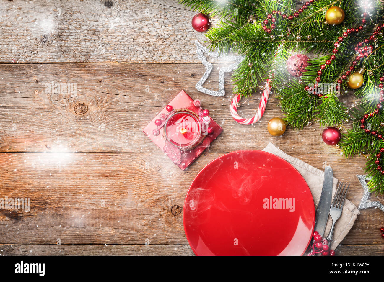 Christmas table place setting with empty red plate and cutlery with ...