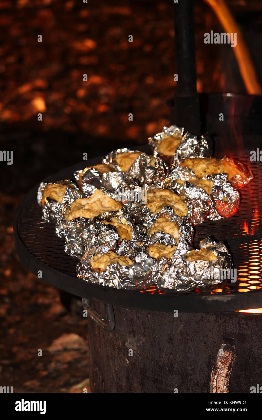 Cooking stuffed baked potatoes outside on a open fire Stock Photo - Alamy