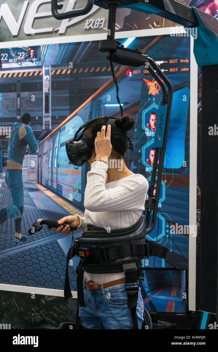 Girl playing VR game wearing Vive headset with gameplay screen behind ...