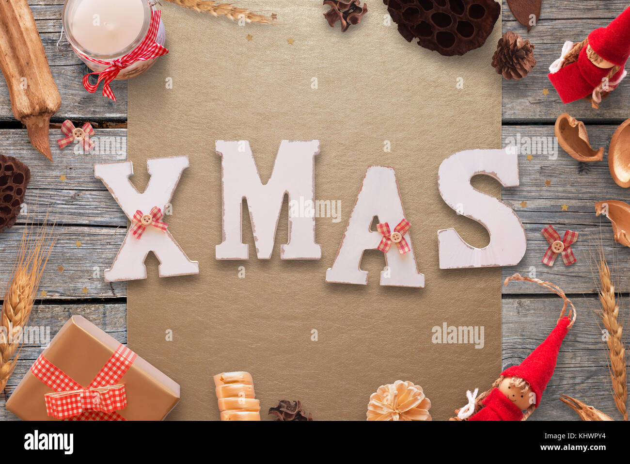 Xmas text on gold cloth and wooden desk with Christmas decorations ...