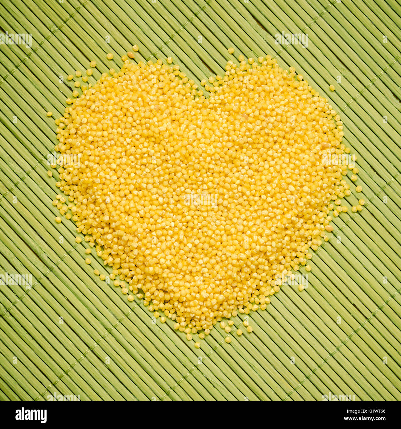 Dieting healthcare concept. Millet groats heart shaped on green straw ...