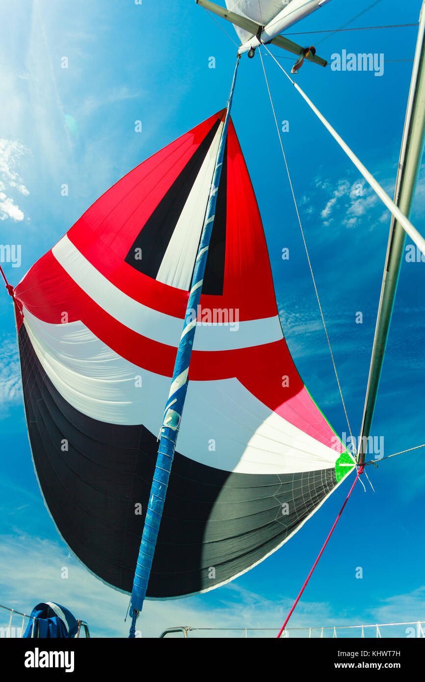 Spinnaker with uphaul on sail boat, blue sky in background. Marine ...