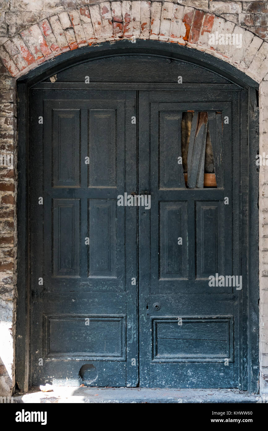 Old Damaged Wooden Doors with Brick Surround Stock Photo - Alamy