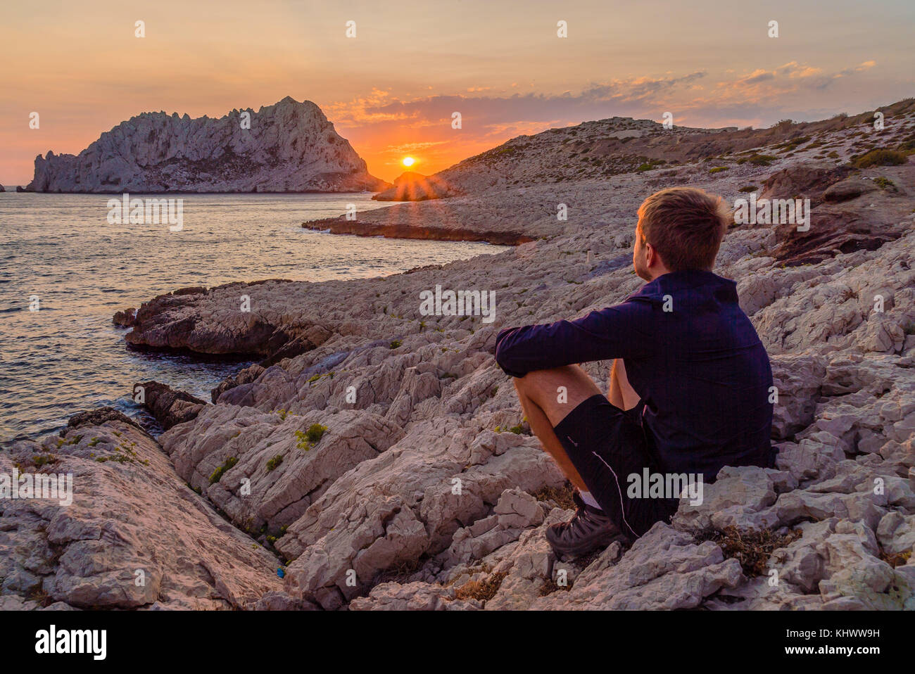 Sun disappearing between two mountains in Les Goudes Stock Photo - Alamy