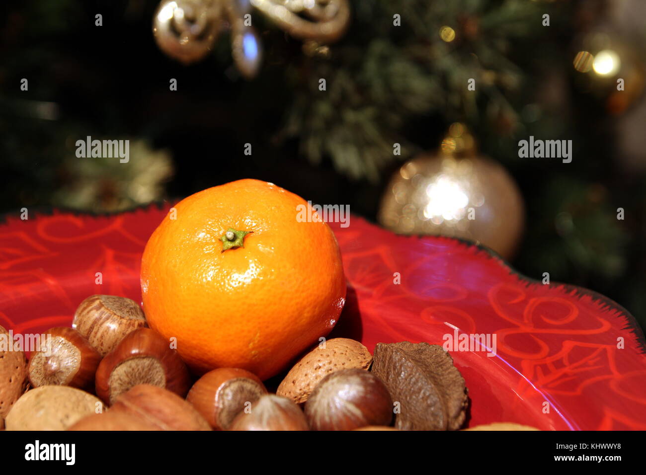 Pretty red Christmas plate with traditional festive almonds, hazelnuts ...