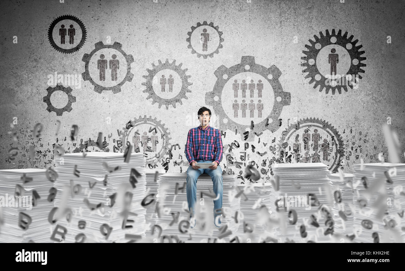 Attractive man sitting on pile of paper documents Stock Photo - Alamy