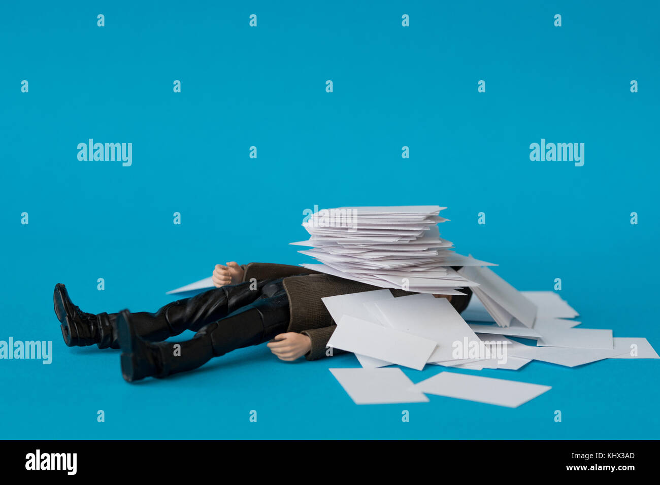 concept of a person swamped with paperwork, blue background Stock Photo ...