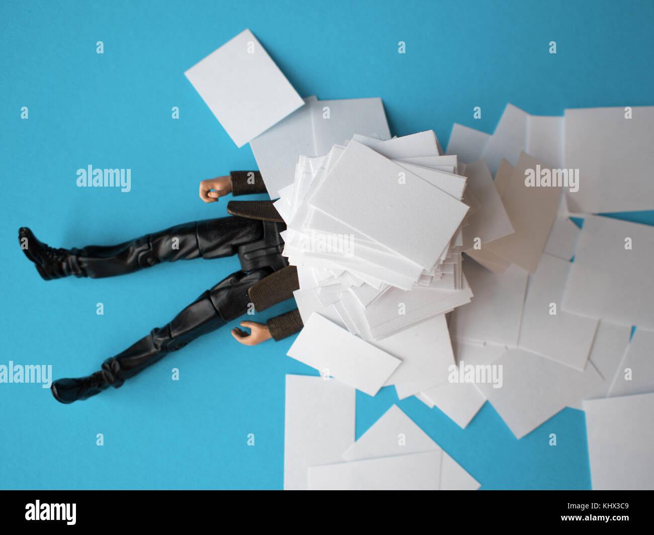 concept of a person swamped with paperwork, blue background Stock Photo ...
