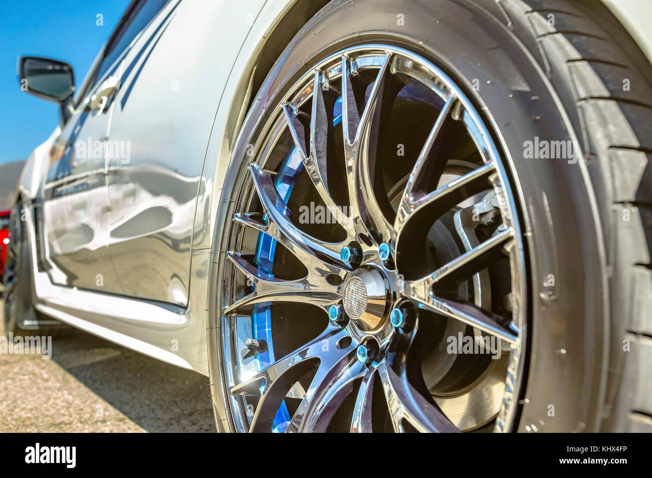 Close up of a car's rim, wheel with no emblem chrome rims and blue ...
