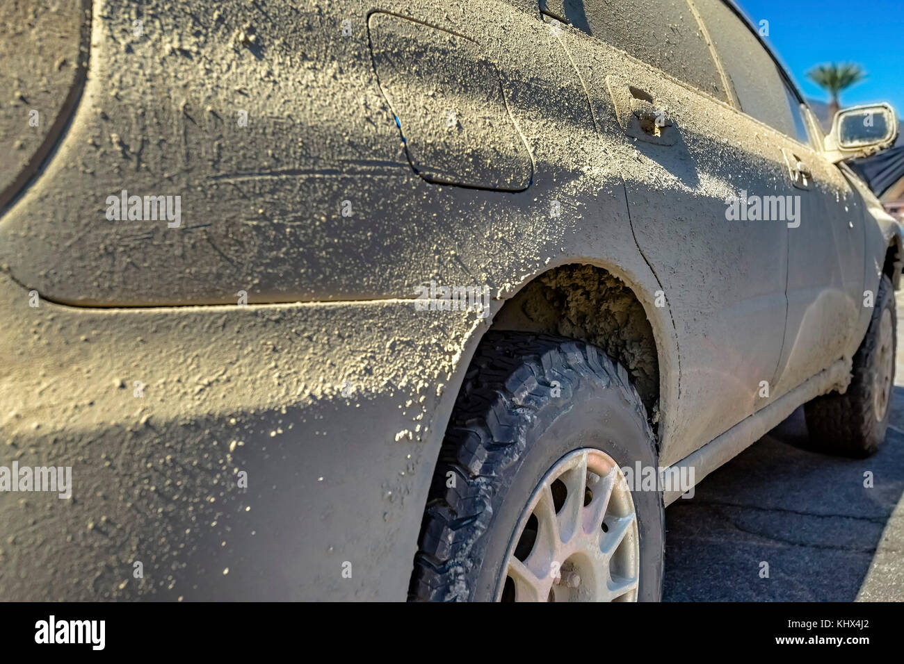 Close-up dry muddy wheels and side doors on car after exploring. Orange ...