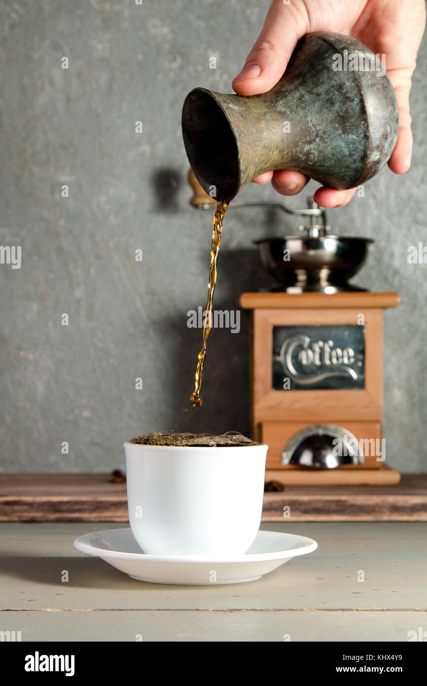 Men Hand Pouring a Cup of Coffee Creating Splash on Wooden Background ...