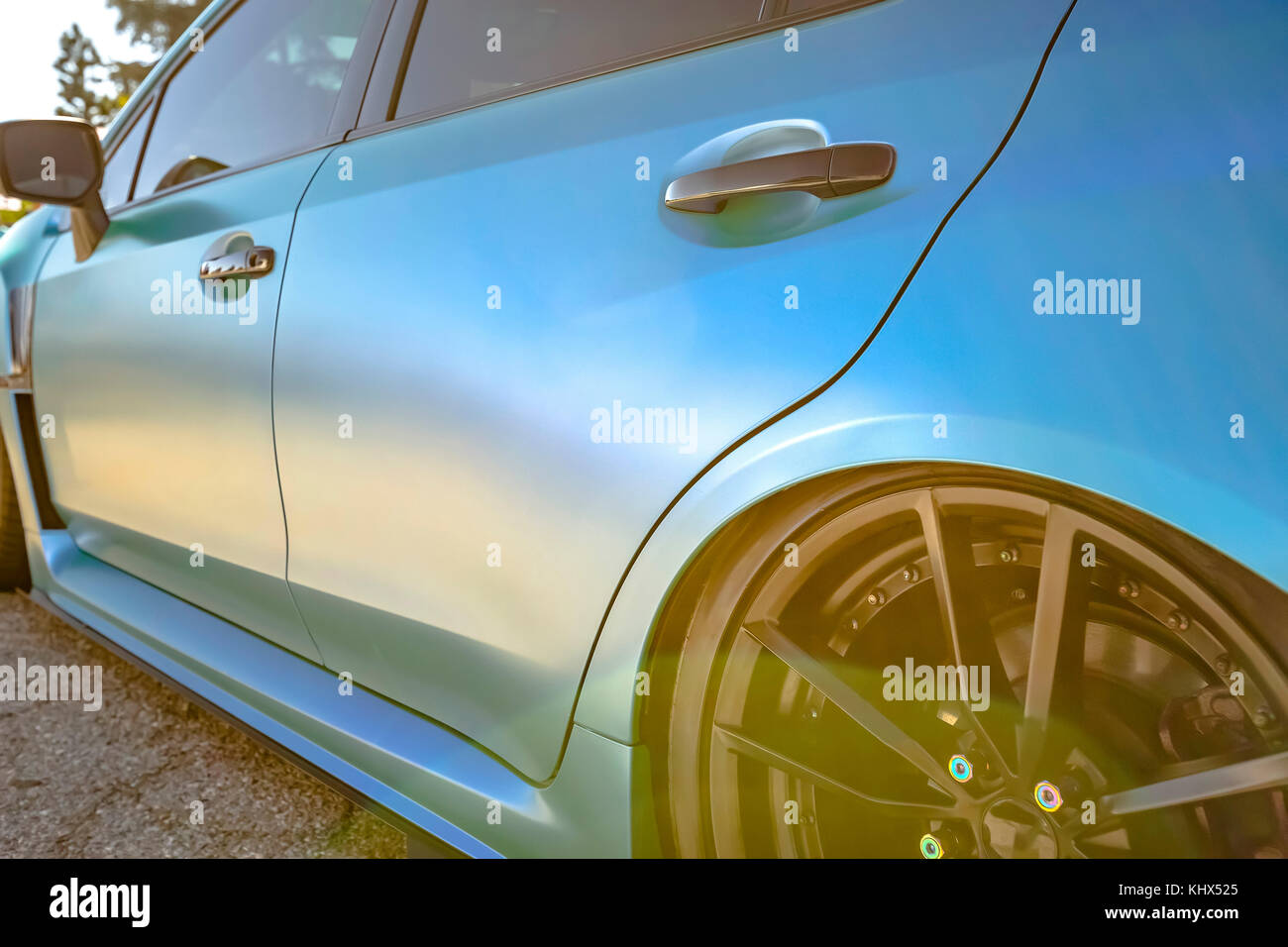 Lens flare in a shot of blue car with black rims. Custom cars in ...