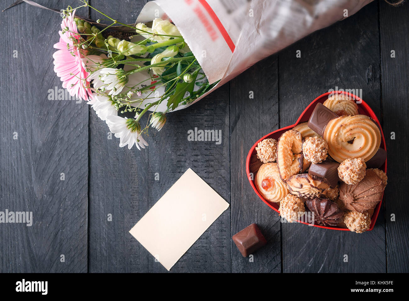 Above view with a message card surrounded by a heart-shaped box full of ...