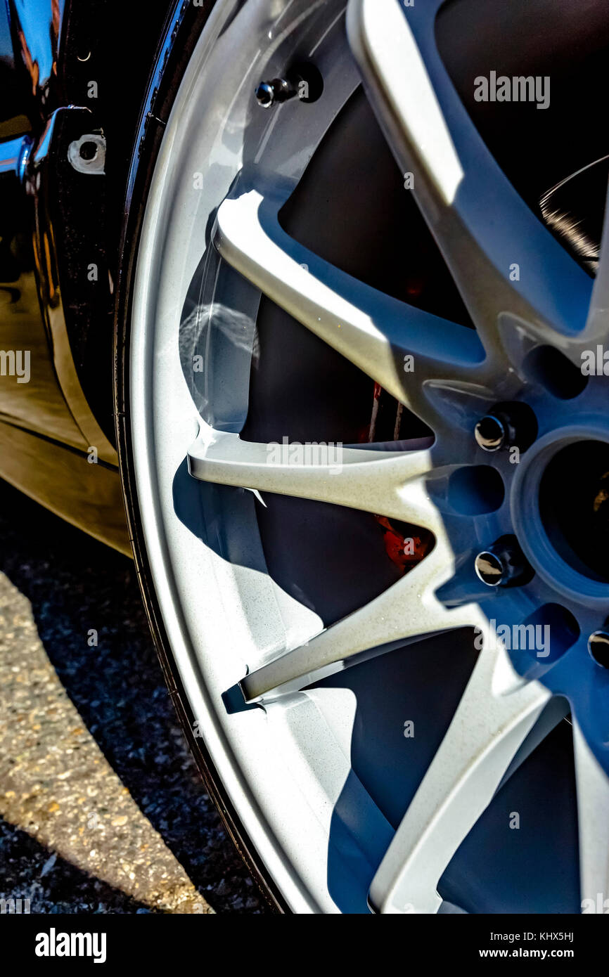 White rims on a black car with red breaks peeking out from the shadows ...