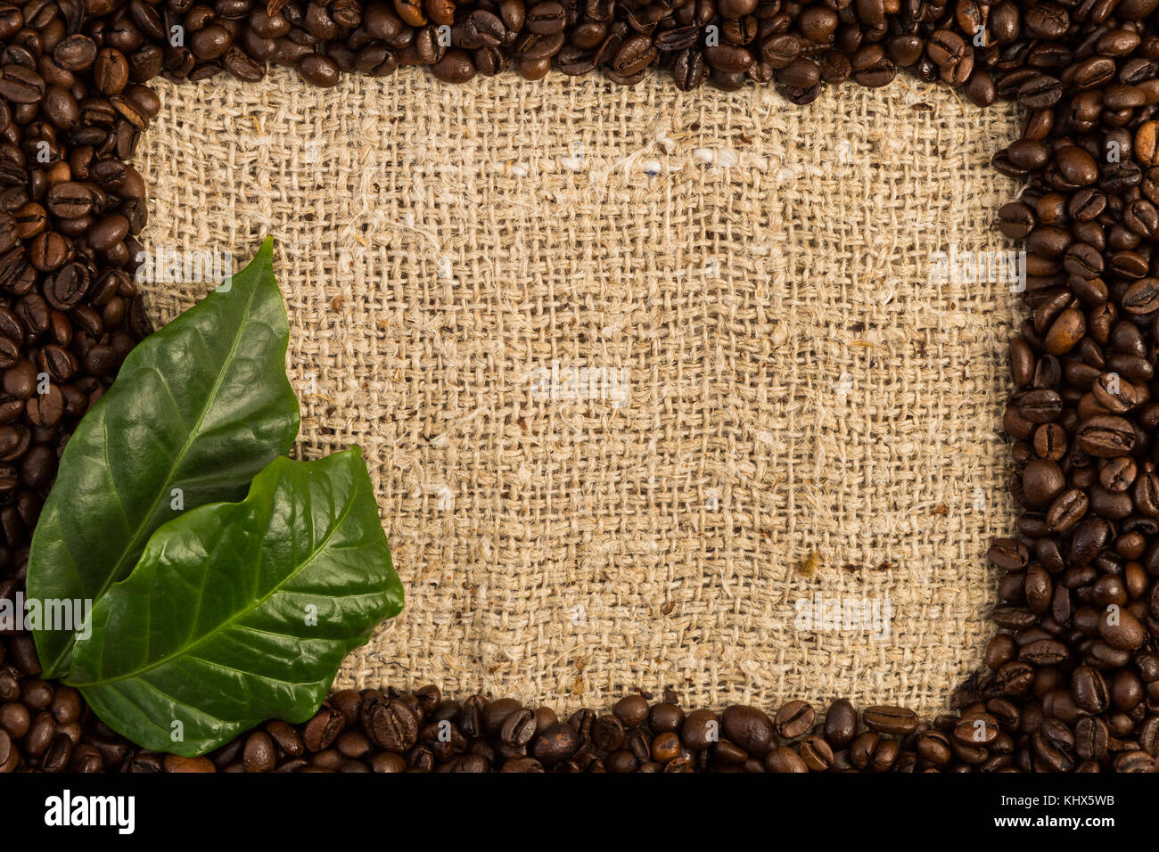 Full coffee frame on jute bag with fresh green leaves and copy space or ...