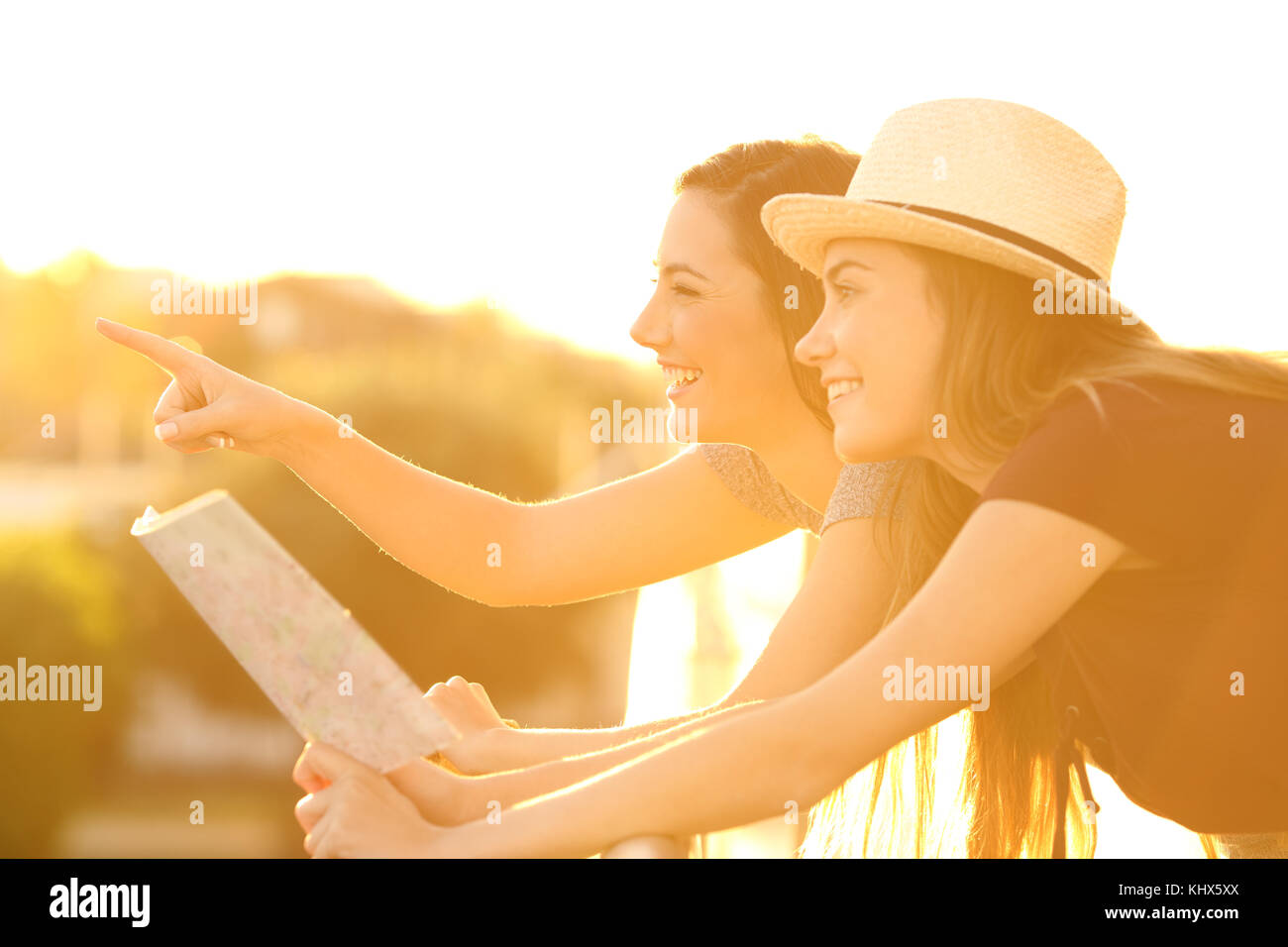 Side view portrait of two tourist friends pointing landmarks in an ...