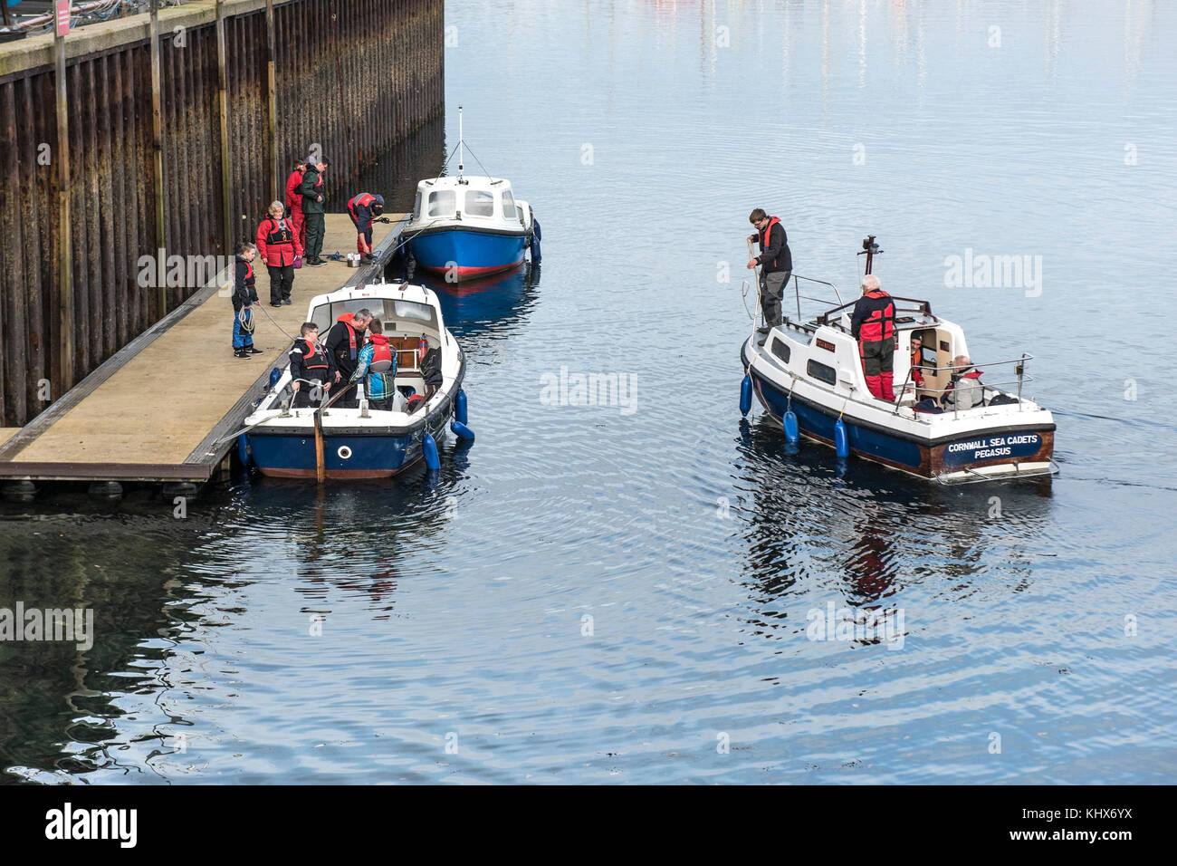 Cornwall Sea Cadets young people boarding three small motorboats in ...