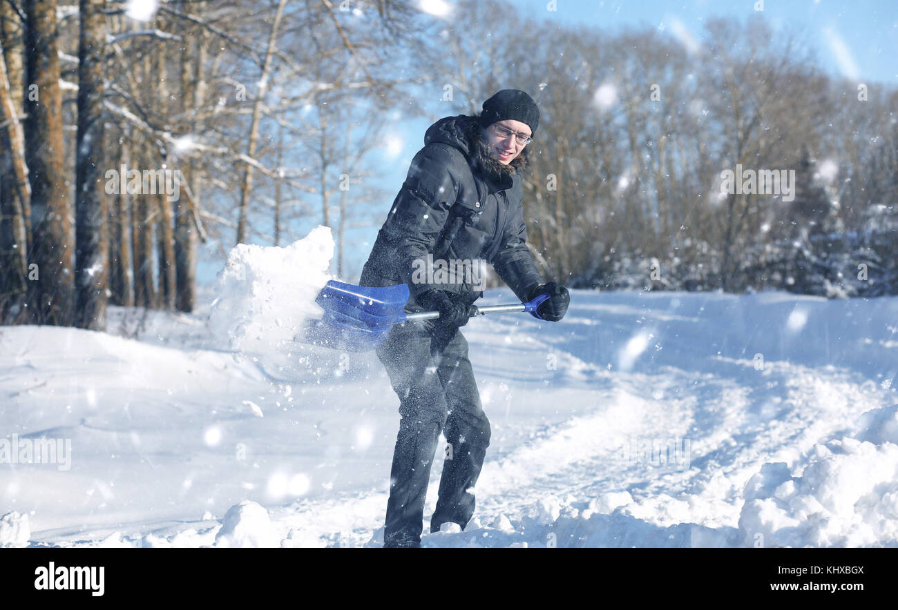 man remove snow with shovel from the road in snowy winter Stock Photo ...