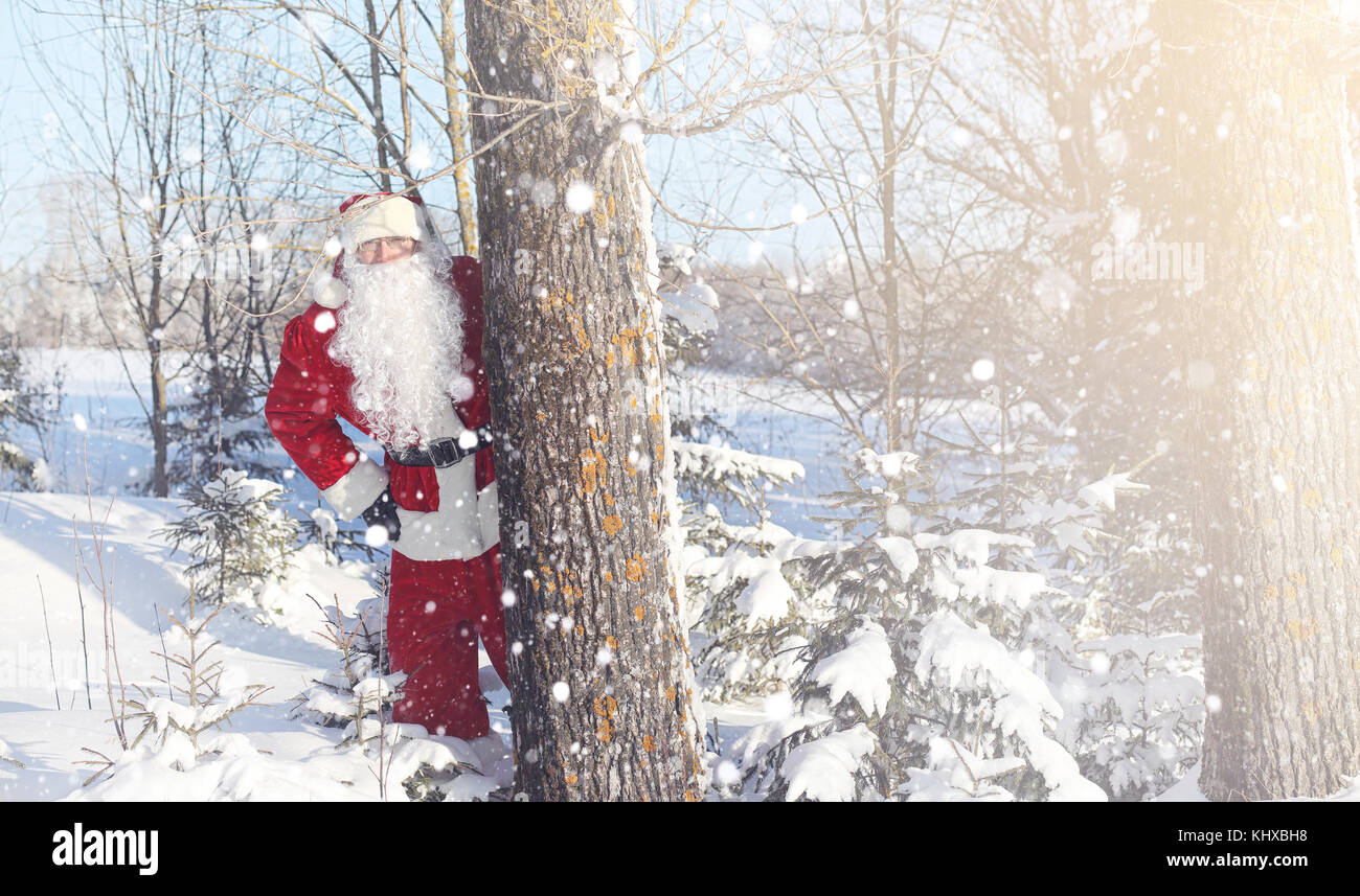 Santa Claus comes with gifts from the outdoor. Santa in a red su Stock ...
