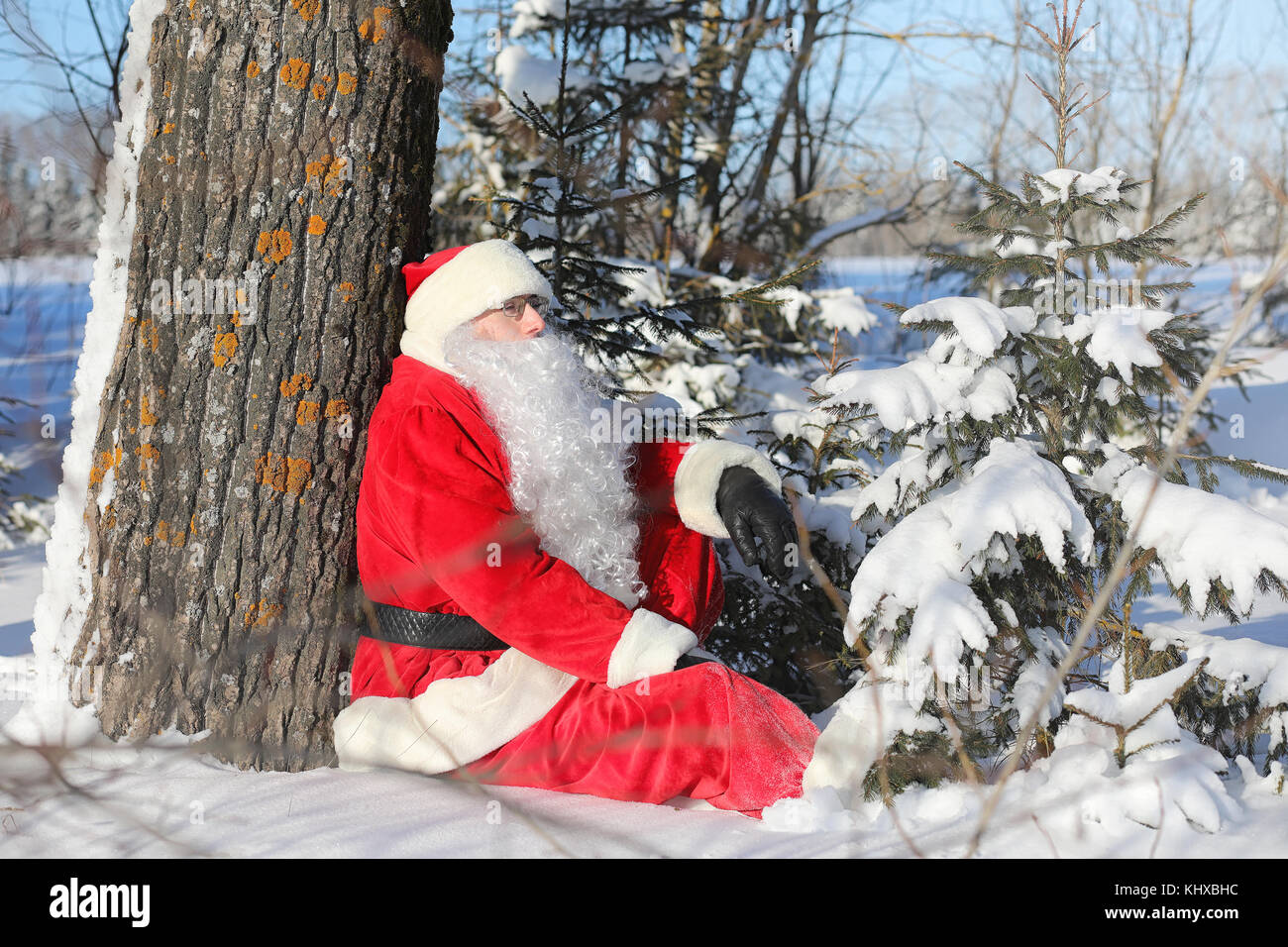 Santa Claus comes with gifts from the outside. Santa in a red su Stock ...