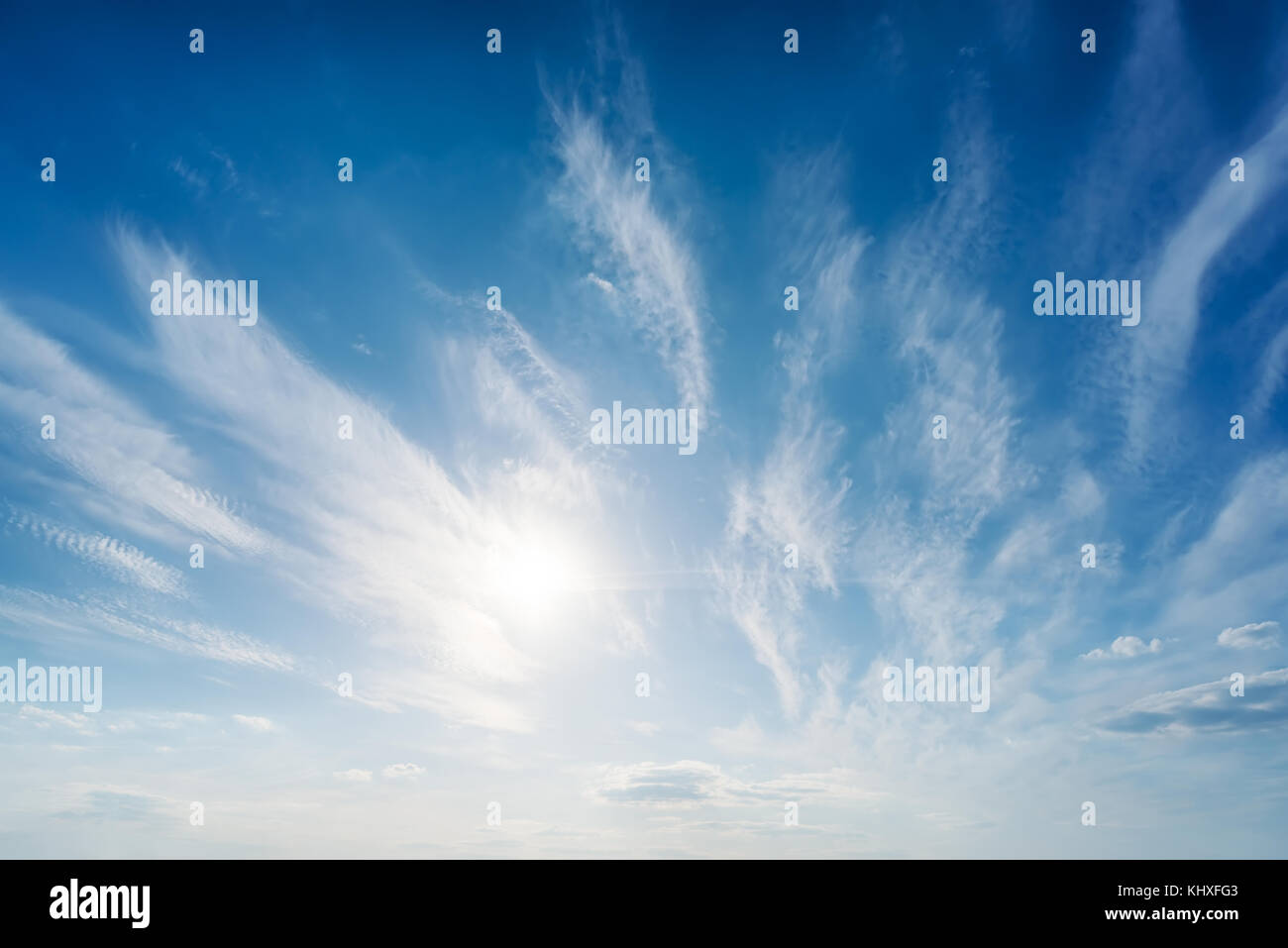low sun and clouds in blue sky Stock Photo - Alamy