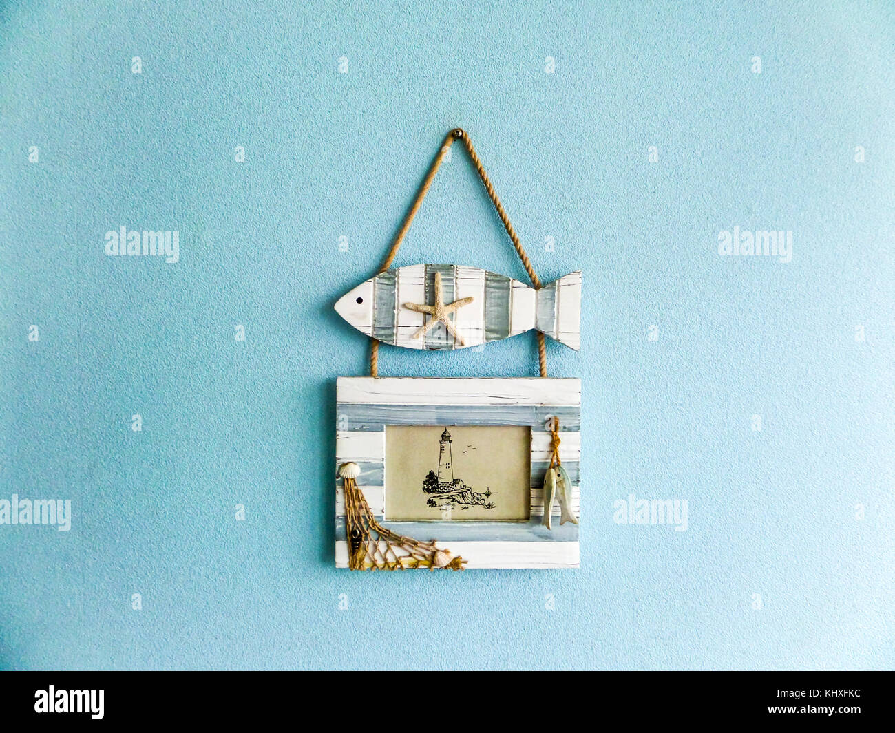 fish and picture frame hang on aqua light color wall Stock Photo - Alamy