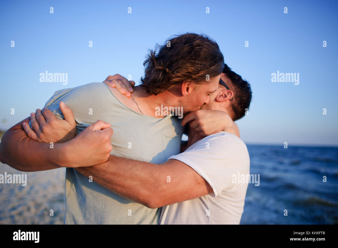 Two men embrace against the background of the sea. They represent a playful kiss Stock Photo - Alamy