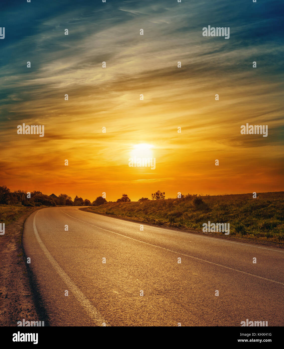asphalt road to horizon and low sun in dramatic clouds Stock Photo - Alamy