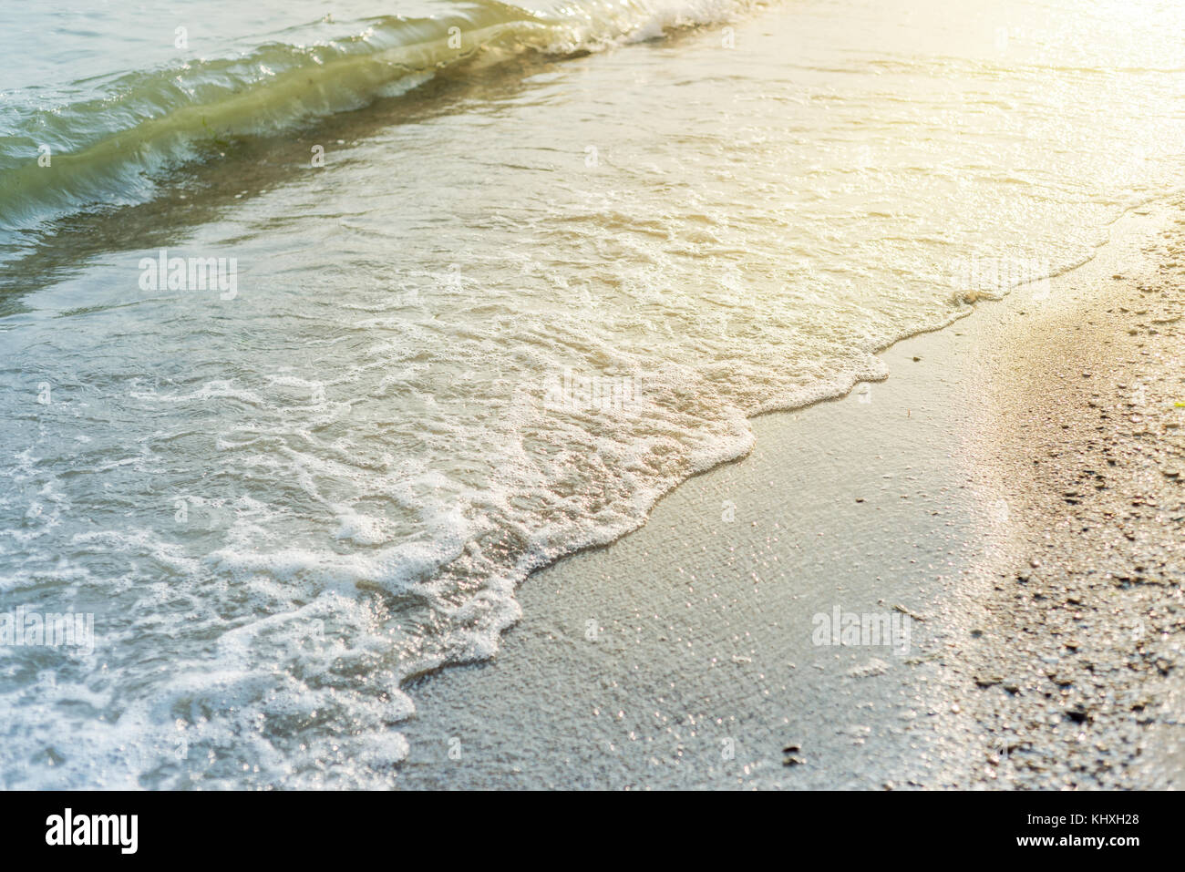 water wave over sand beach and sun reflections Stock Photo - Alamy
