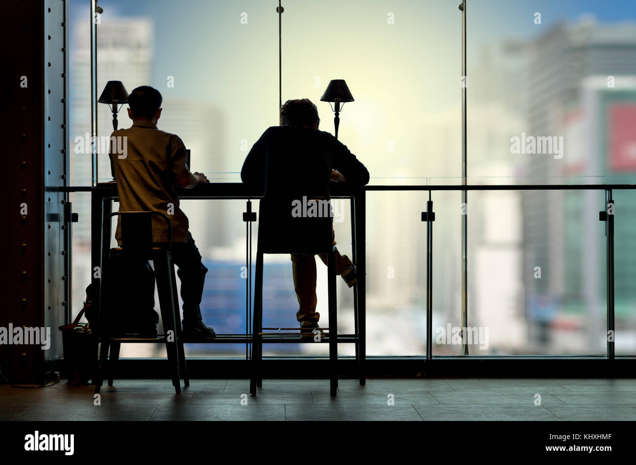 Silhouette of Man works at the workplace beside the windows on the ...