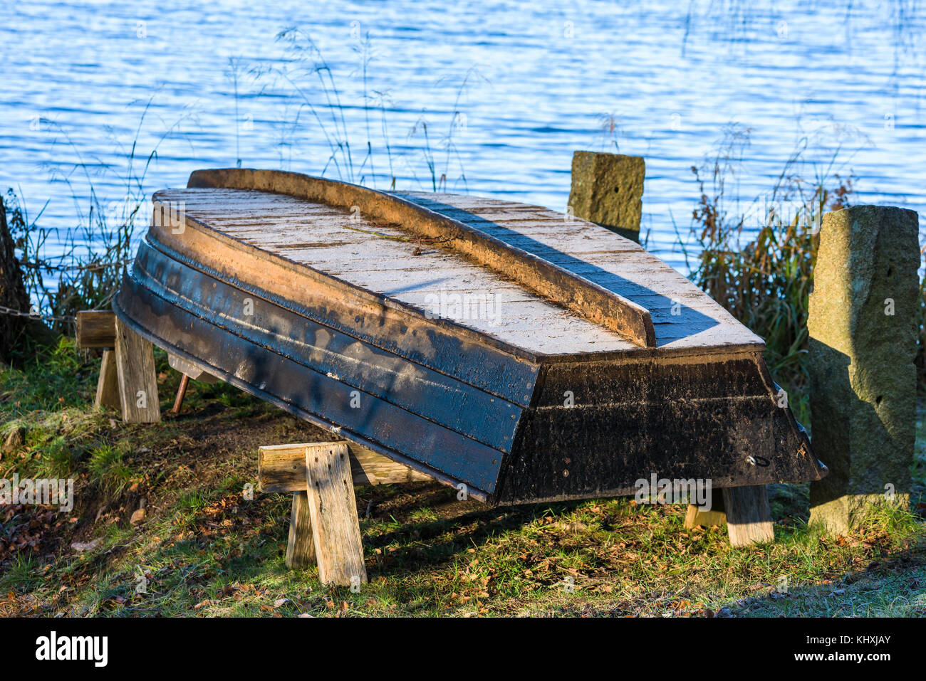 Upside down flat bottom rowboat on land over winter Stock Photo - Alamy