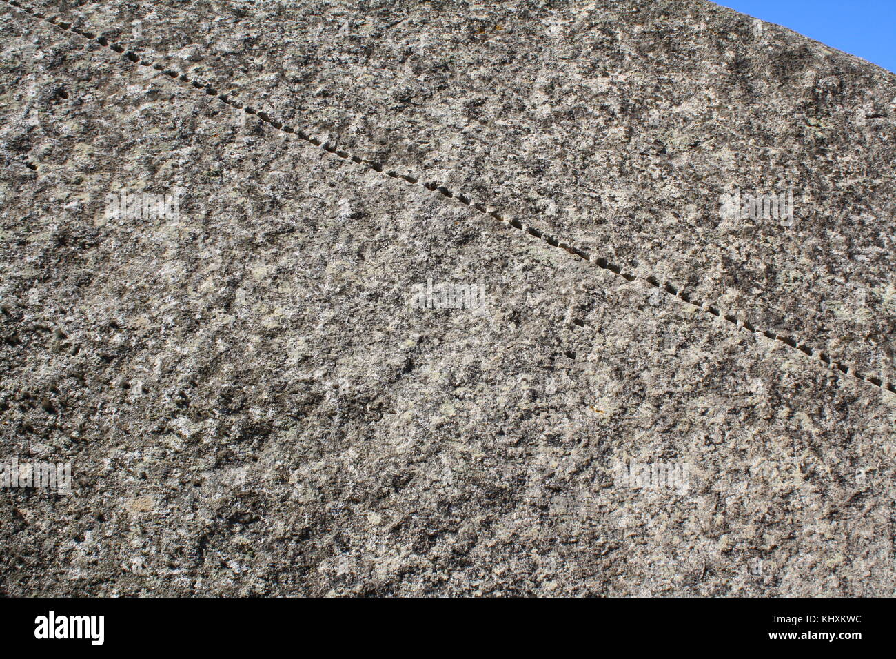 A big granite rock with drilled holes in a line Stock Photo - Alamy