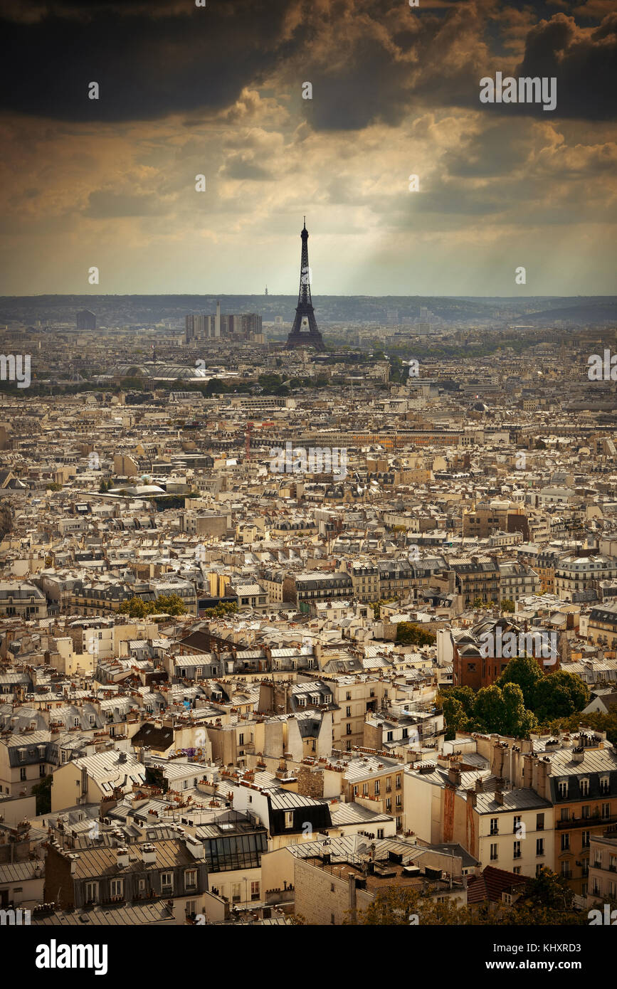 Paris city skyline rooftop view with sun ray and Eiffel Tower at sunset ...