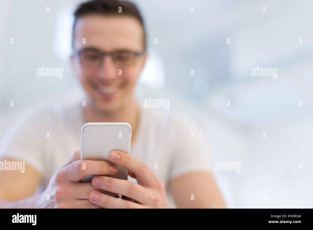 Handsome casual young man using a mobile phone at home Stock Photo - Alamy