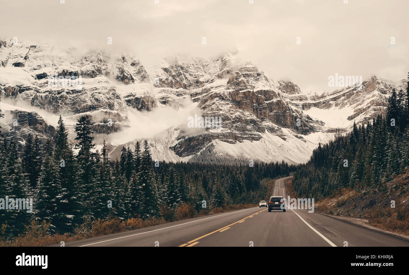 Highway with snow capped mountain forest and car in Banff National Park ...