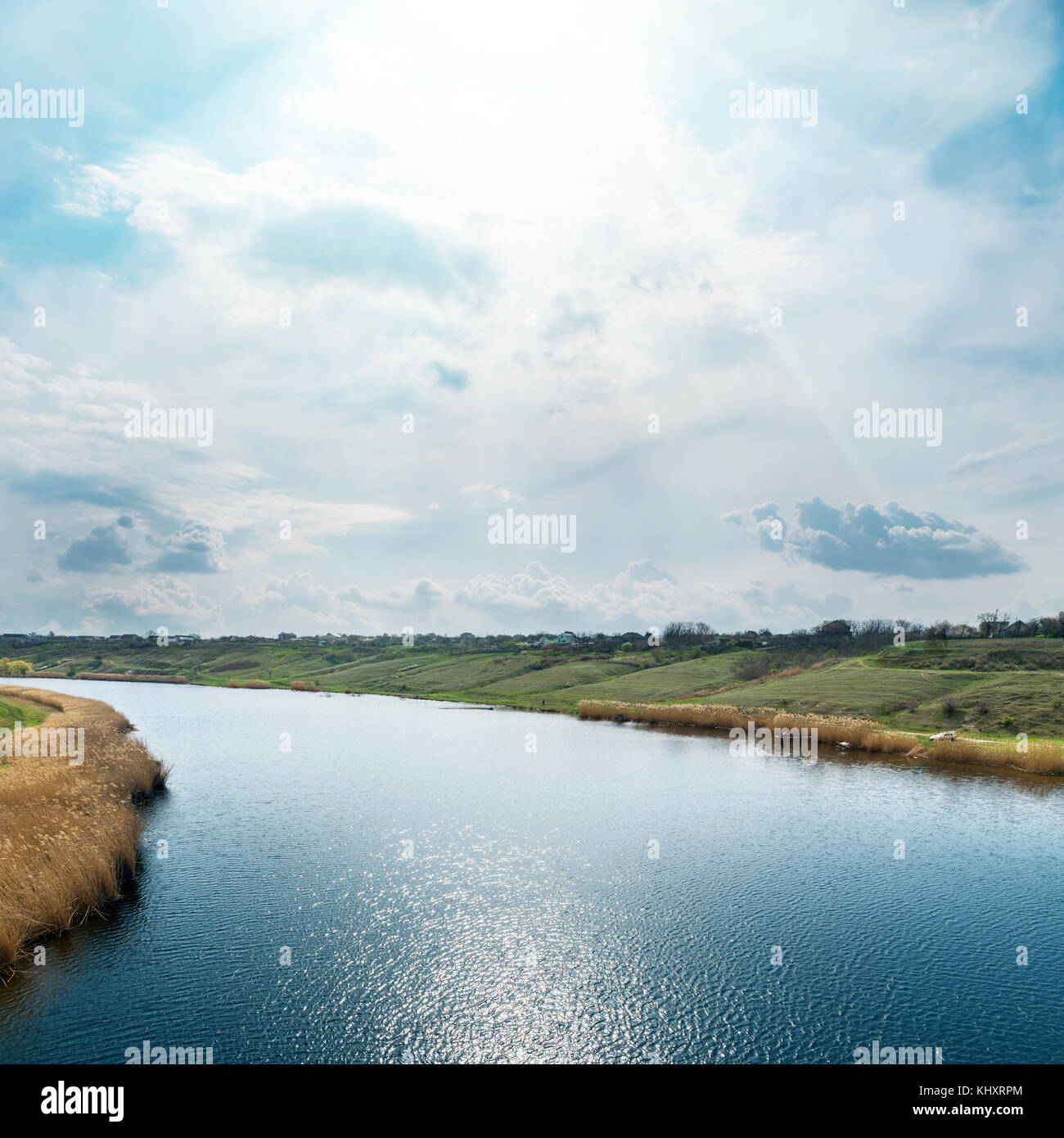 blue sky with sun and clouds over river with reflections Stock Photo ...