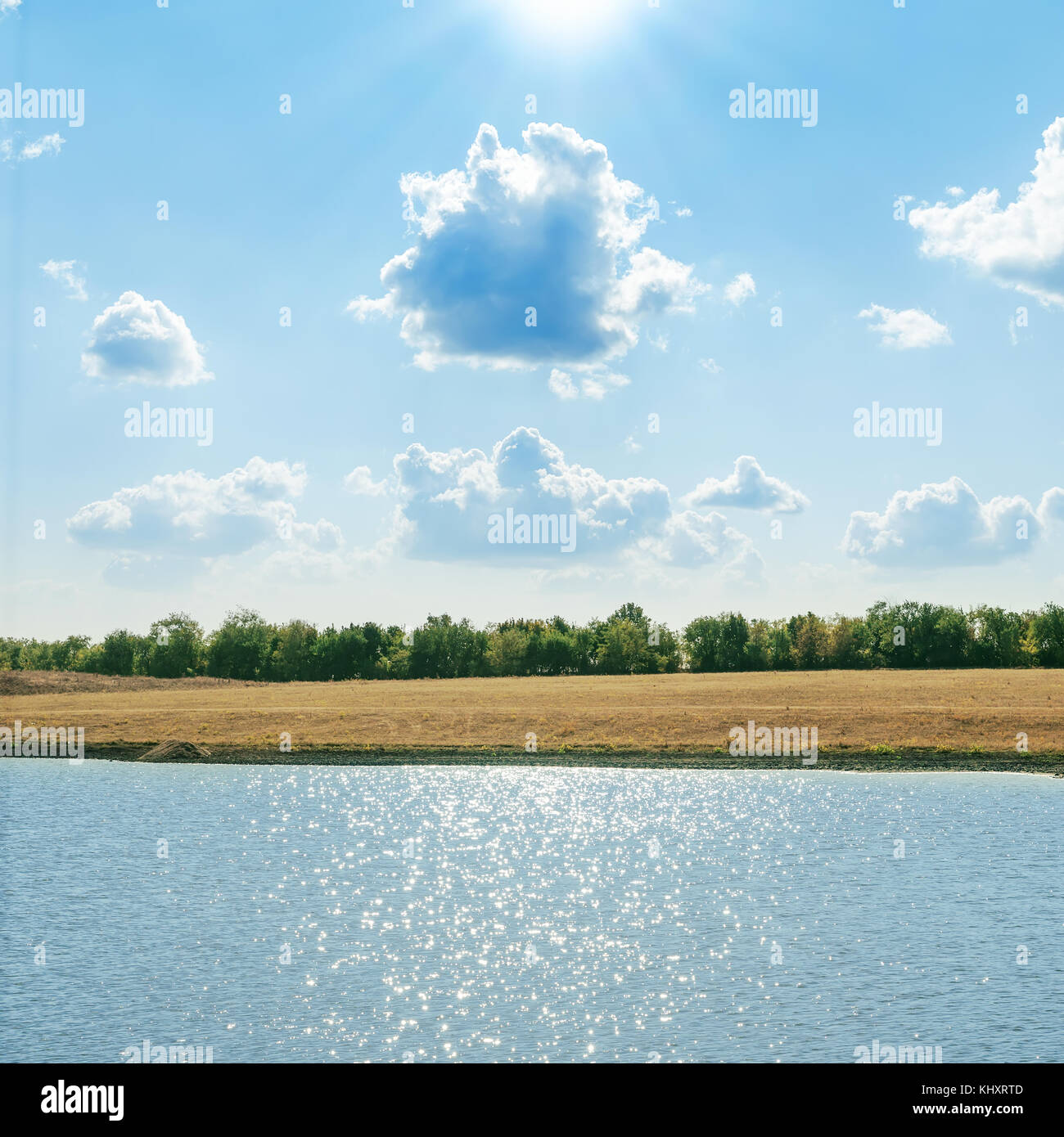 dramatic clouds in blue sky with sun over pond Stock Photo - Alamy