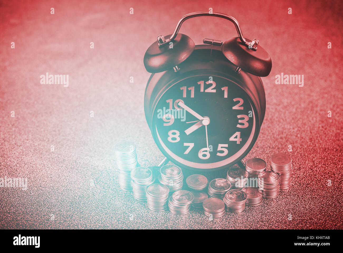Alarm clock and step of coins stacks on working table, time for savings ...